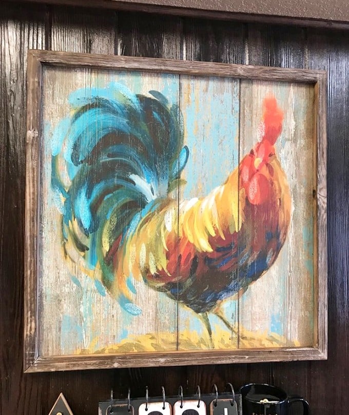 A colorful rooster painting watches over diners—the unofficial mascot and silent judge of whether you've properly cleaned your plate.