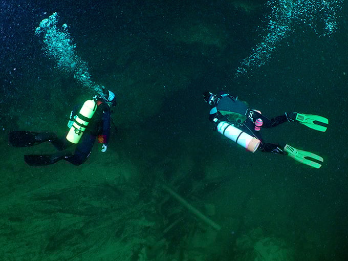 Scuba divers exploring an underwater world most of us only see in documentaries. Like astronauts, but with better views and more fish.