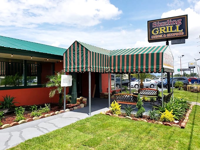 The Sizzling Grill's striped awning beckons like a culinary carnival tent, promising comfort food that won't require a second mortgage.