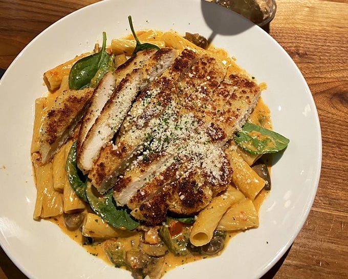 Romano-crusted chicken lounging on a bed of rigatoni like it owns the place—which, after one bite of that creamy sauce, you'll agree it does.