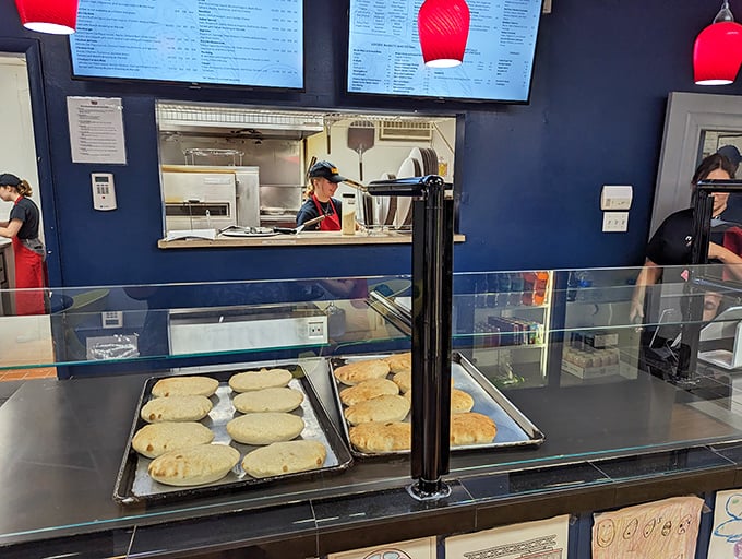 The calzone display case – showcasing pockets of joy waiting to release their cheesy secrets with each satisfying bite.