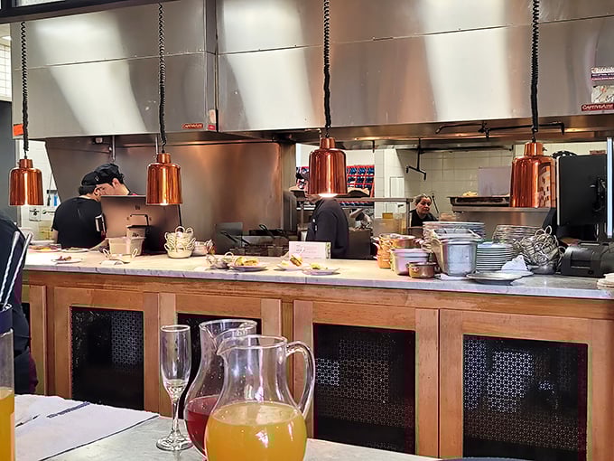 The open kitchen concept lets you watch culinary magic happen in real time. Those copper pendant lights aren't just stylish—they're spotlights for the star chefs.