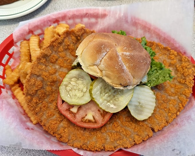 This isn't just a pork tenderloin—it's a crispy-edged monument to excess that makes the bun look like it's playing a supporting role.