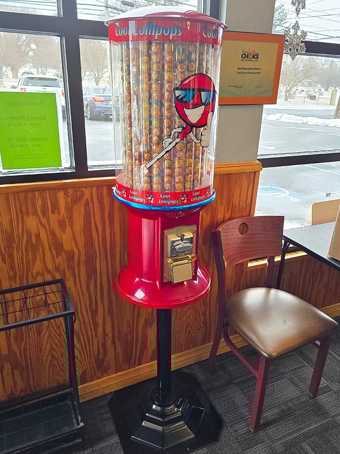 A lollipop dispenser standing sentinel by the door—because every good meal deserves a sweet goodbye. Childhood nostalgia in mechanical form.