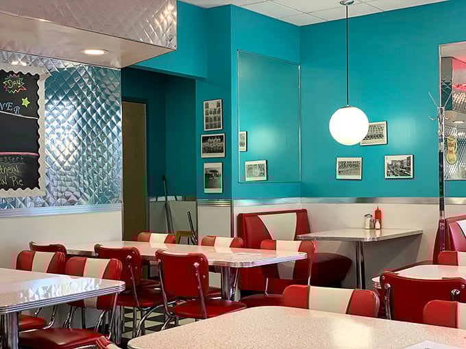 The teal walls adorned with framed memories tell stories of the diner's past, while the red and white chairs invite you to become part of its present.