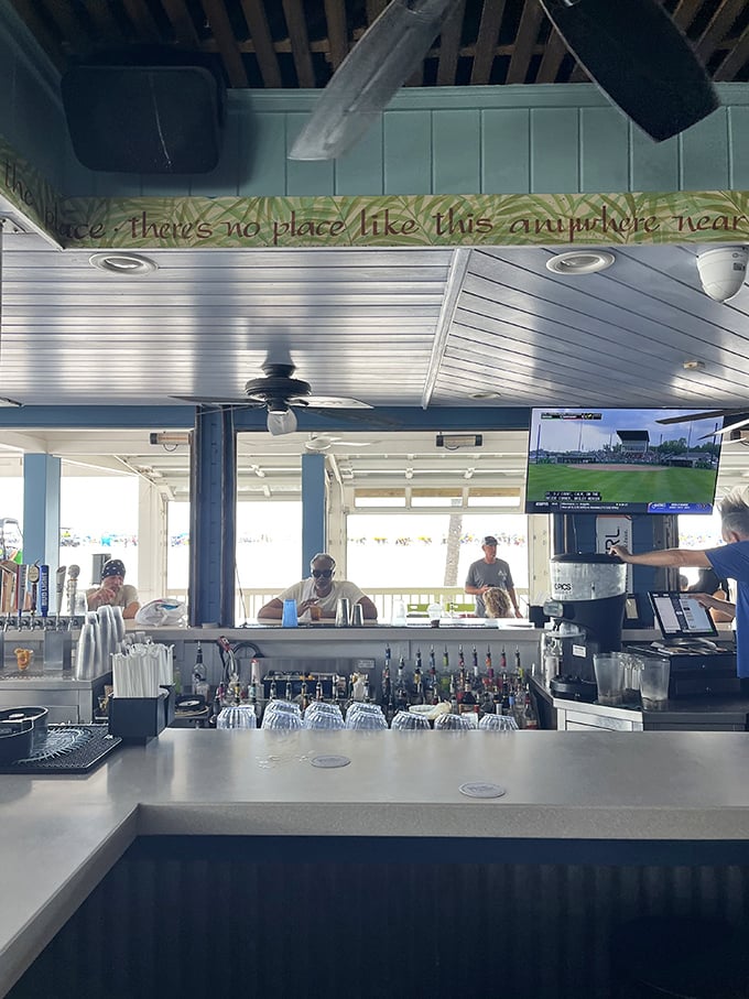 "There's no place like this anywhere near"—the sign above the bar speaks truth as bartenders craft cocktails with the Gulf as their backdrop.