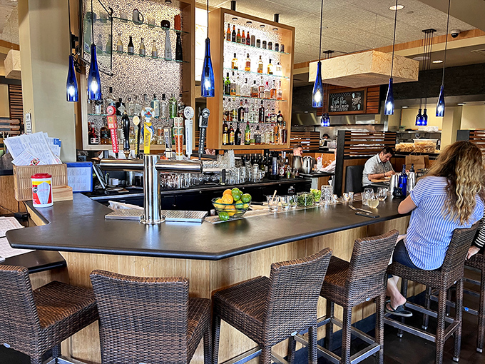 The bar at Pacific Catch—where blue bottles glow like ocean treasures and cocktail magic happens. Your next great conversation is just a barstool away.