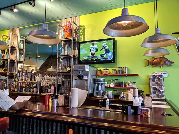 The bar area glows with lime-green walls and industrial pendant lighting, creating the perfect backdrop for pre-burger libations or post-burger recovery.