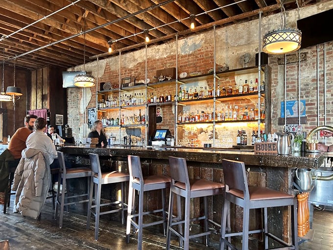 The bar area beckons with warm lighting and exposed brick—a place where cocktails are crafted with the same care as the kitchen's finest dishes.