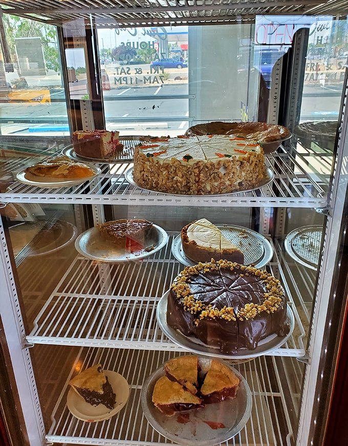 The dessert case—where willpower goes to die and diet plans are forgotten amid chocolate cakes and fruit pies.