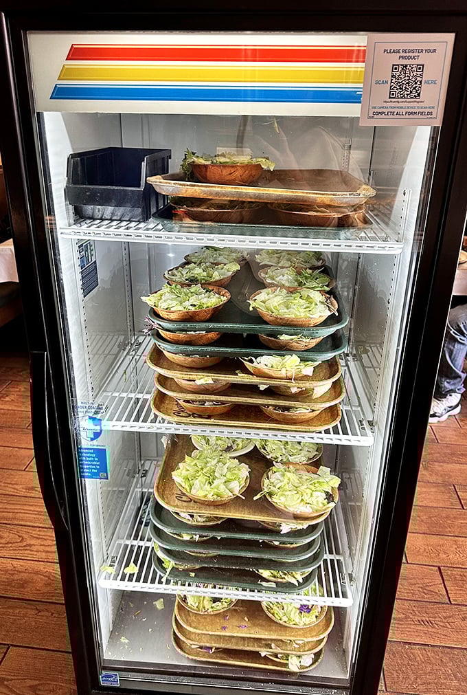 Pre-prepped salads waiting their turn – because sometimes efficiency trumps tableside preparation when hunger is on the line.