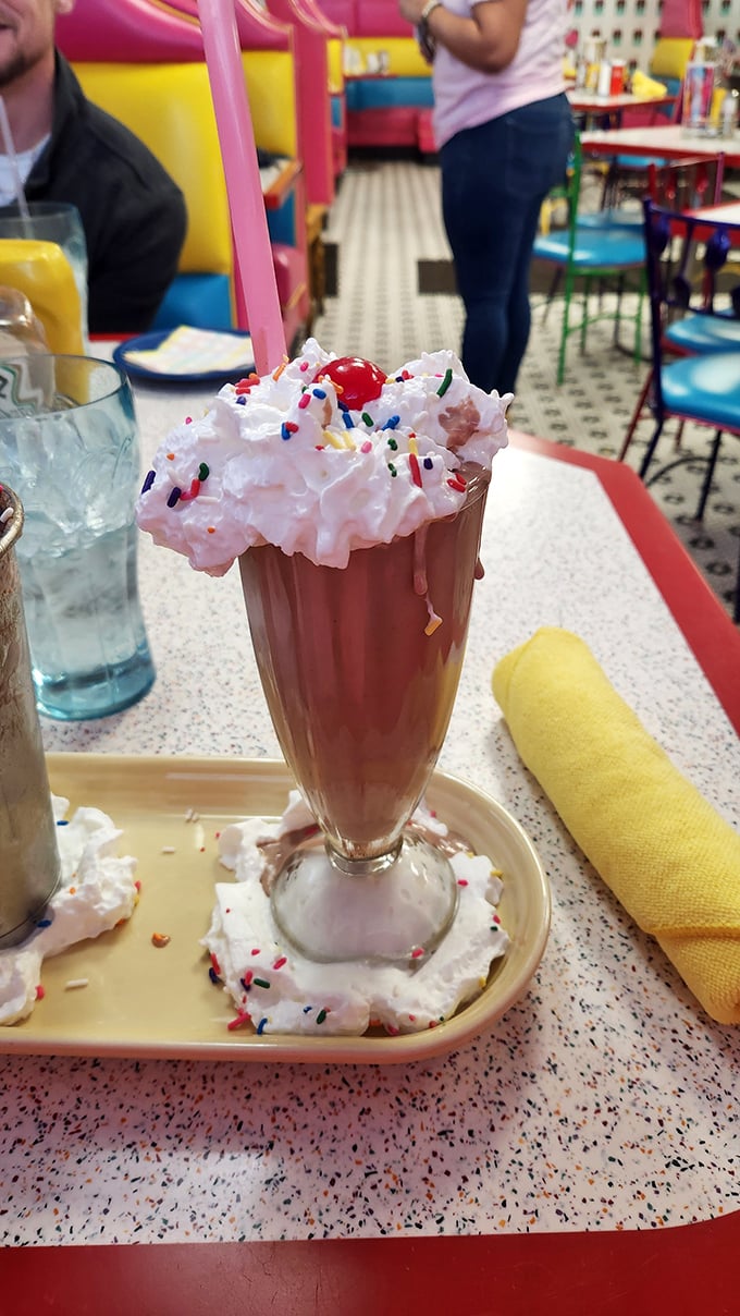 This chocolate milkshake with its cloud of whipped cream and rainbow sprinkles isn't just a dessert—it's what childhood dreams promised adulthood would be. 