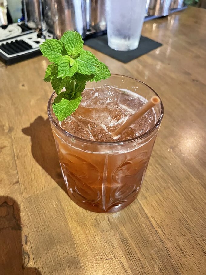 A cocktail garnished with fresh mint that looks like it should come with its own tiny umbrella and a mandatory vacation day.