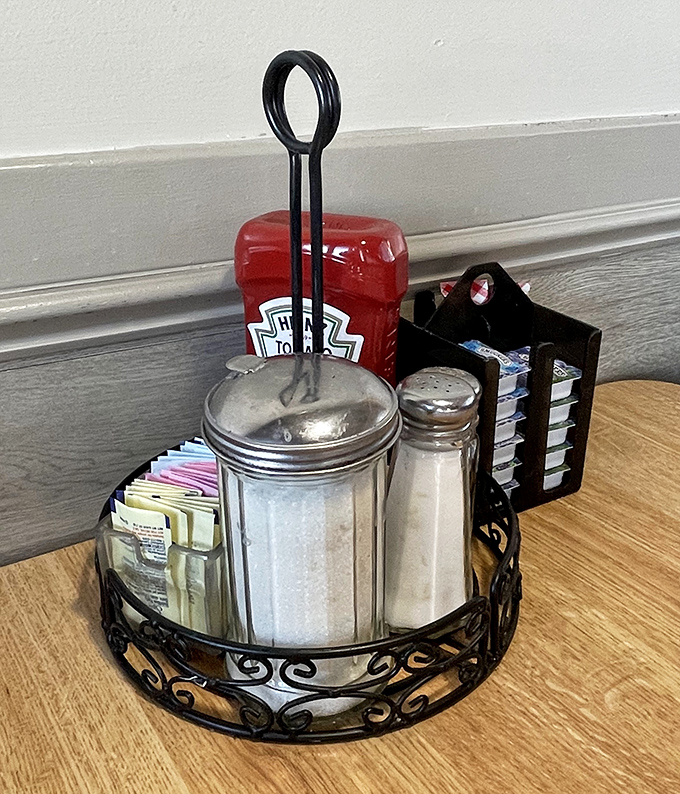 The table-top essentials – sugar, salt, and condiments arranged with the precision of artifacts in a museum dedicated to American dining traditions.
