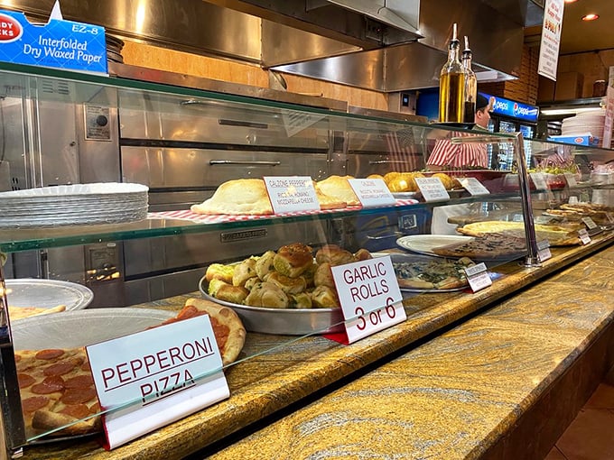 The display counter—where pizza dreams are born and diet resolutions go to die. Each sign promises a different path to delicious satisfaction. 