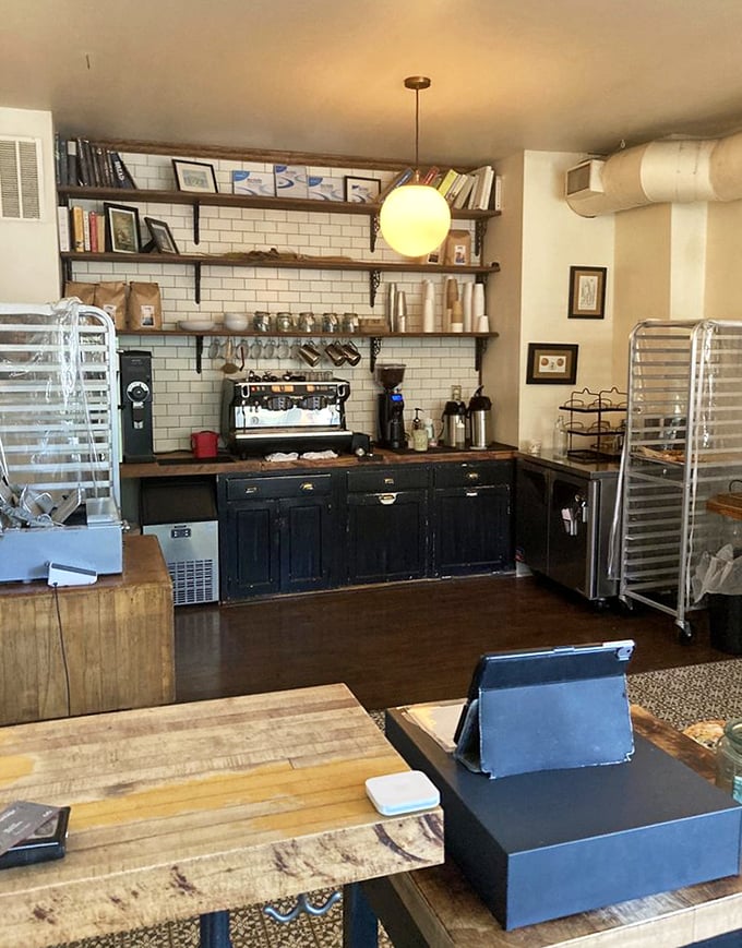 Behind the counter, subway tiles and wooden shelves create that perfect backdrop for the real stars: the breads and pastries waiting for their forever homes.