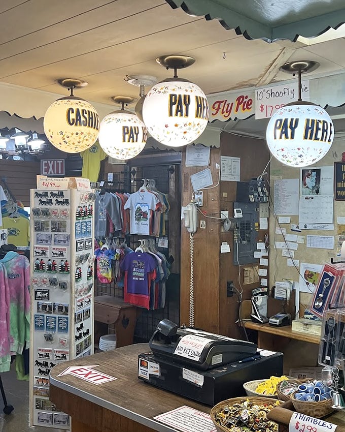 Old-fashioned cash register surrounded by globe lights spelling "PAY HERE" – retail nostalgia that actually works perfectly.
