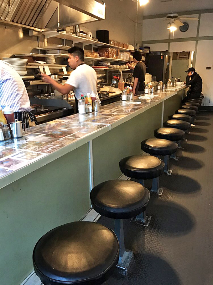 The counter isn't just for eating—it's front-row seating to the breakfast theater, where hash browns are the headlining act. 