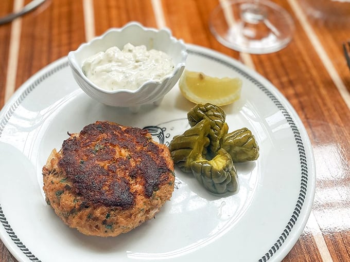 A perfectly seared crab cake flanked by pickled peppers—proof that simplicity, when executed flawlessly, is the ultimate luxury.