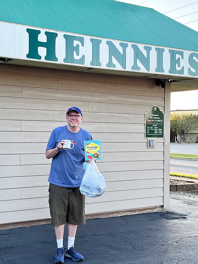 The image shows a visitor clearly delighted with their Heinnies haul – that smile says everything about what awaits inside.