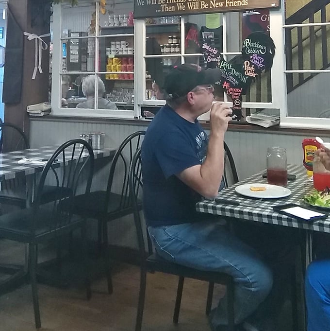 A patron enjoys his meal in peaceful solitude – the universal dining position of someone who has discovered food worth savoring without distraction.