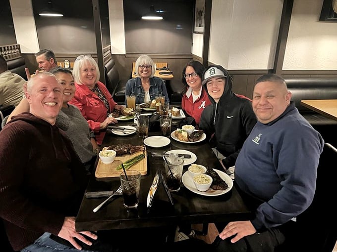 Happy diners sharing stories and steaks—the universal language of good food bringing people together around a table of plenty.