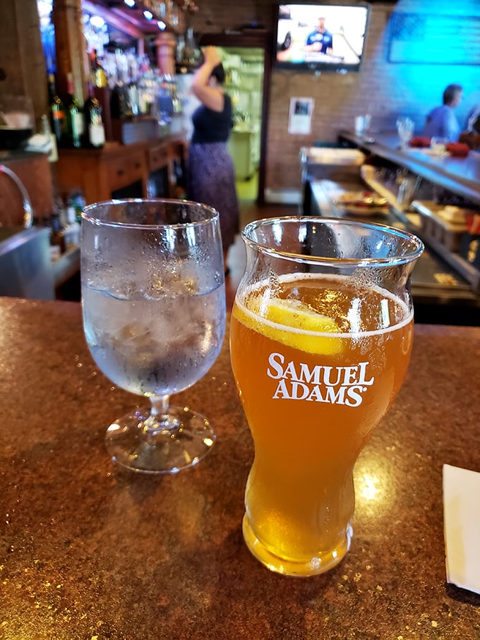 A perfectly poured Samuel Adams alongside water that's actually served in proper glassware—because Harper's knows presentation matters even with the basics.