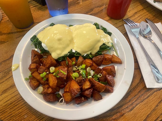 Eggs Benedict that makes you understand why people wait in line for breakfast—hollandaise sauce cascading over spinach like a savory waterfall.