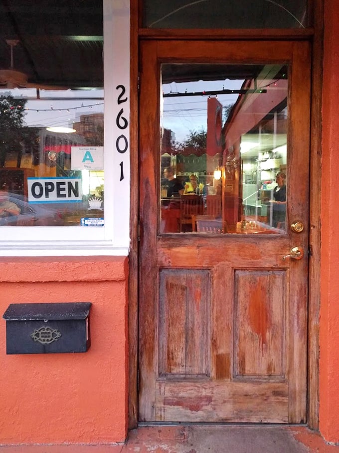 The weathered wooden door stands like a portal to flavor country. No velvet ropes or bouncers—just honest hospitality waiting inside.