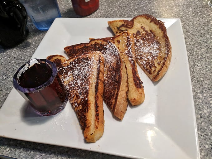 French toast dusted with powdered sugar and served with syrup—breakfast's answer to "How can we make bread even more irresistible?"