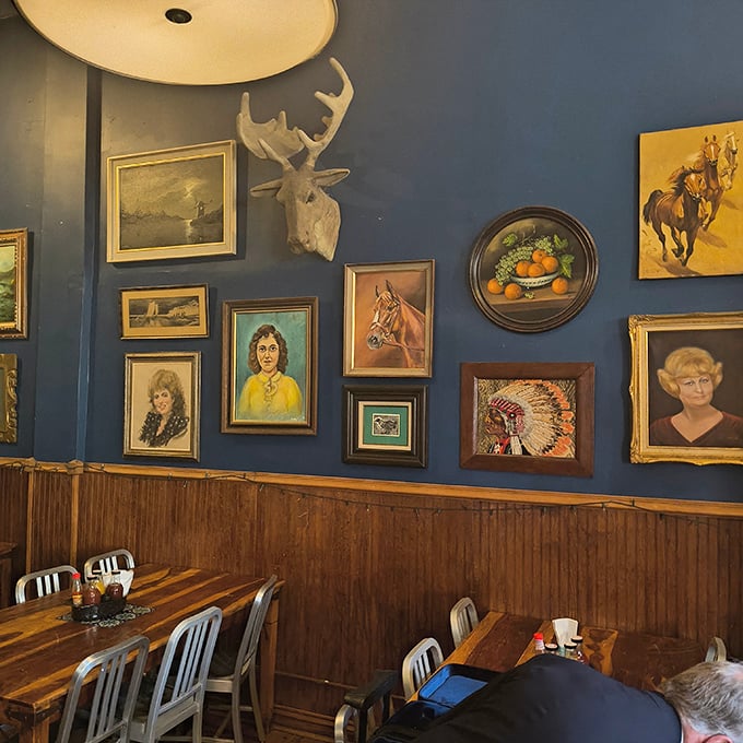 The eclectic wall art collection feels like raiding your coolest grandparent's attic – vintage portraits, wildlife mounts, and horse paintings creating a uniquely American tableau.