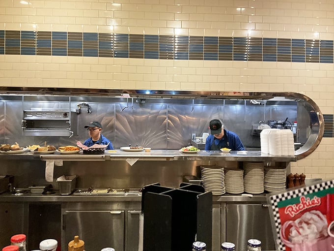 The kitchen's choreographed chaos is visible through the pass – where short-order magic happens at speeds that would impress NASCAR pit crews.