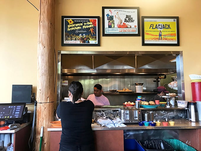 Behind every great breakfast is a bustling kitchen where morning magic happens, framed by vintage-inspired posters that celebrate food culture.