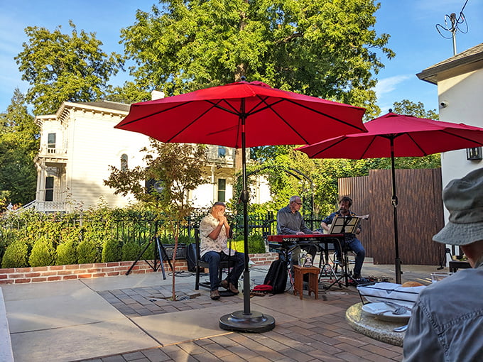 Outdoor dining under red umbrellas—where live music and fresh air conspire to make your steak taste even better.