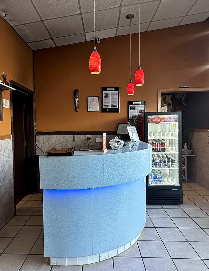 The reception counter glows with blue light, a modern touch in this temple of traditional flavors where every guest is welcomed.