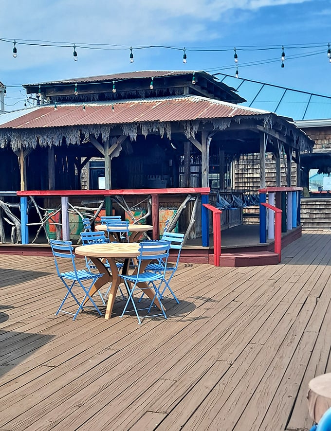 The outdoor deck where fresh air enhances every bite. Those blue chairs aren't just seating—they're front-row tickets to relaxation.