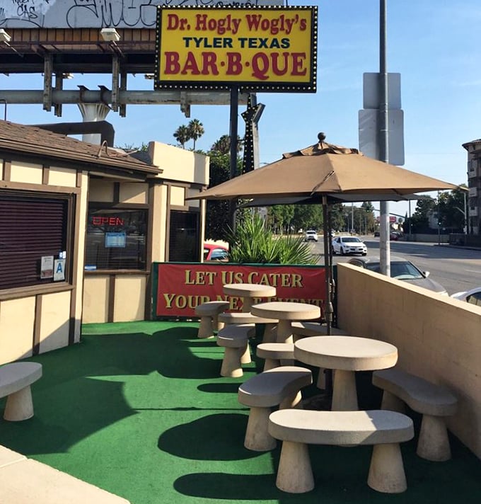 The outdoor patio—where the green astroturf and concrete tables say "we put our effort into the smoker, not the landscaping."