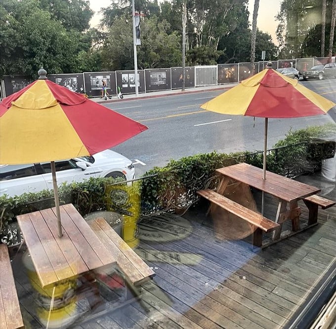 Outdoor seating with red and yellow umbrellas that match the train car's vibrant colors—because even your al fresco dining should stay on brand.