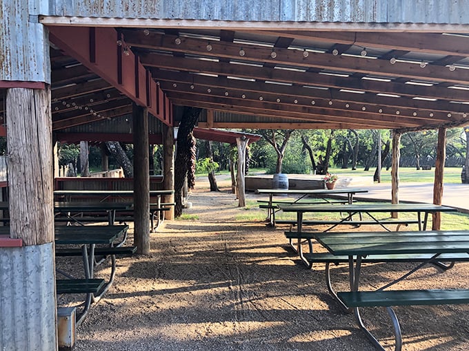 Outdoor dining under corrugated metal and Texas sky – where picnic tables become the setting for unforgettable meals.