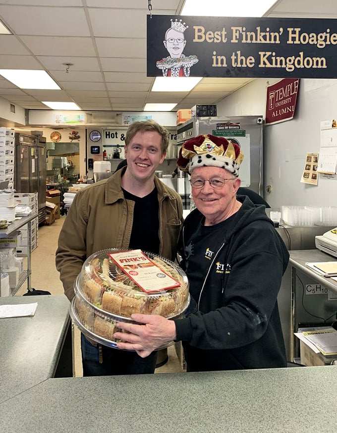 The pride of craftsmanship shines through as a tray of perfectly assembled hoagies is presented—the crown jewels of Philadelphia's sandwich kingdom.