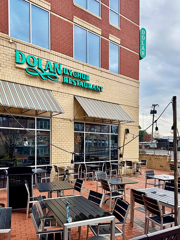 The outdoor patio offers al fresco dining beneath the distinctive turquoise sign—a perfect spot for people-watching while savoring Central Asian delights.