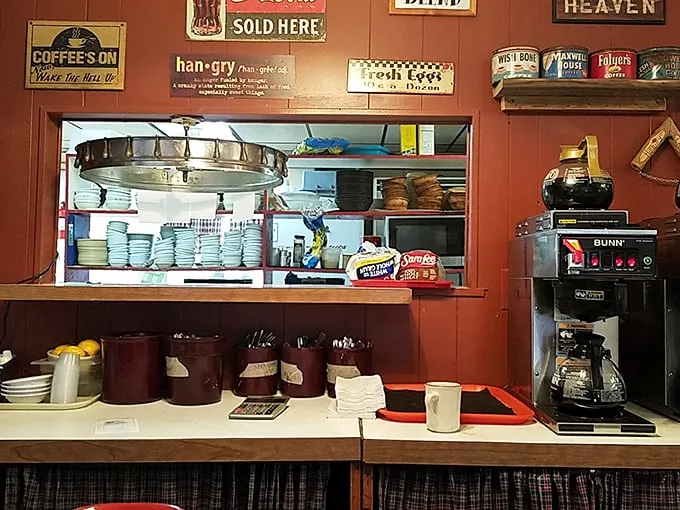 The kitchen pass reveals the beating heart of the operation—stacked plates ready for action and a coffee maker that never gets a day off. Americana in its natural habitat.