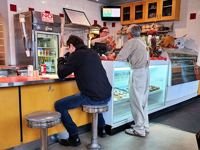 Where deli dreams begin – the counter where sandwiches are ordered and anticipation builds. Those display cases hold the promise of desserts worth saving room for.