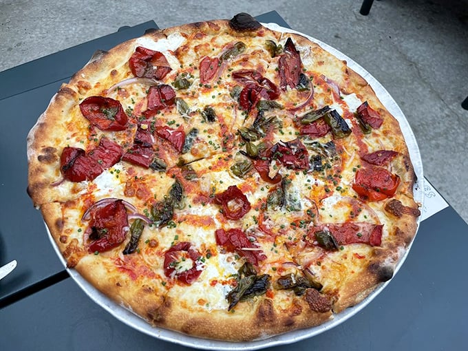 Roasted sweet peppers and capers dance across this pizza like colorful notes in a culinary composition that hits all the right chords.