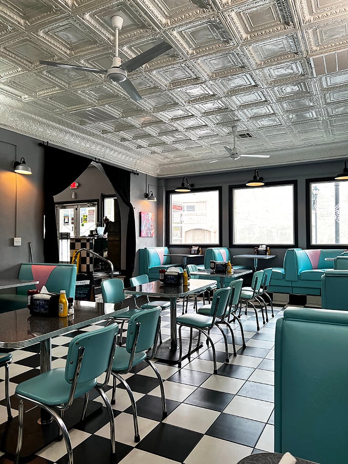 The spacious dining room showcases authentic tin ceiling tiles and classic diner seating arrangements beautifully.