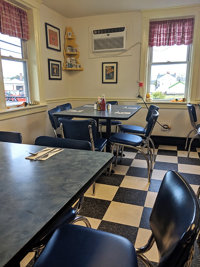 The corner table—prime diner real estate. Those plaid curtains and checkered floor have witnessed more local gossip than a small-town newspaper.