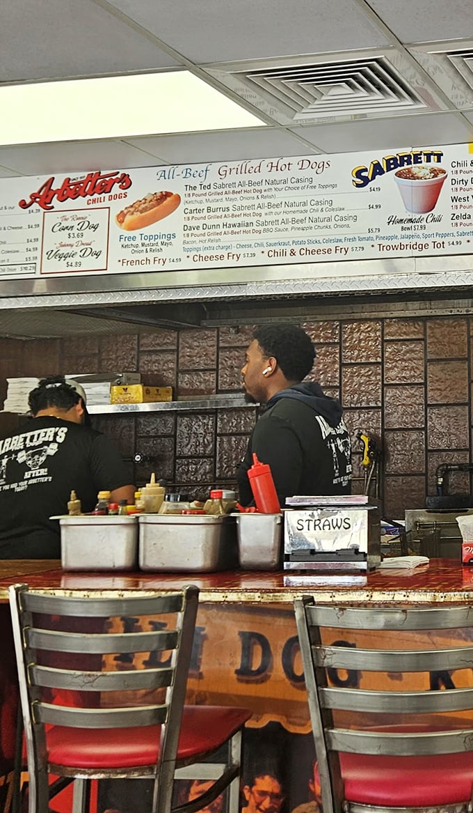 Where the hot dog magic happens—skilled hands prepare each order with the efficiency that comes only from years of practice.