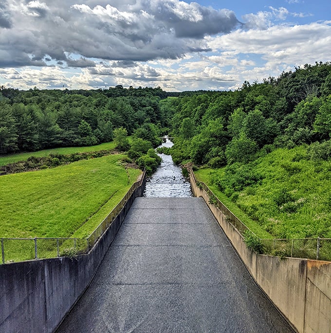 The dam spillway creates its own river symphony, channeling water through concrete corridors back to the wild.