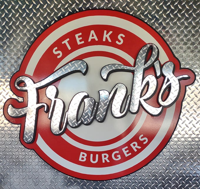 The logo gleams against diamond plate metal—industrial chic that says, "We're too busy making great food to worry about interior design trends."