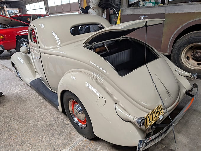 The cream-colored 1936 Ford 5-Window Coupe sits in quiet elegance, a testament to the days when curves weren't just beautiful—they were engineering.